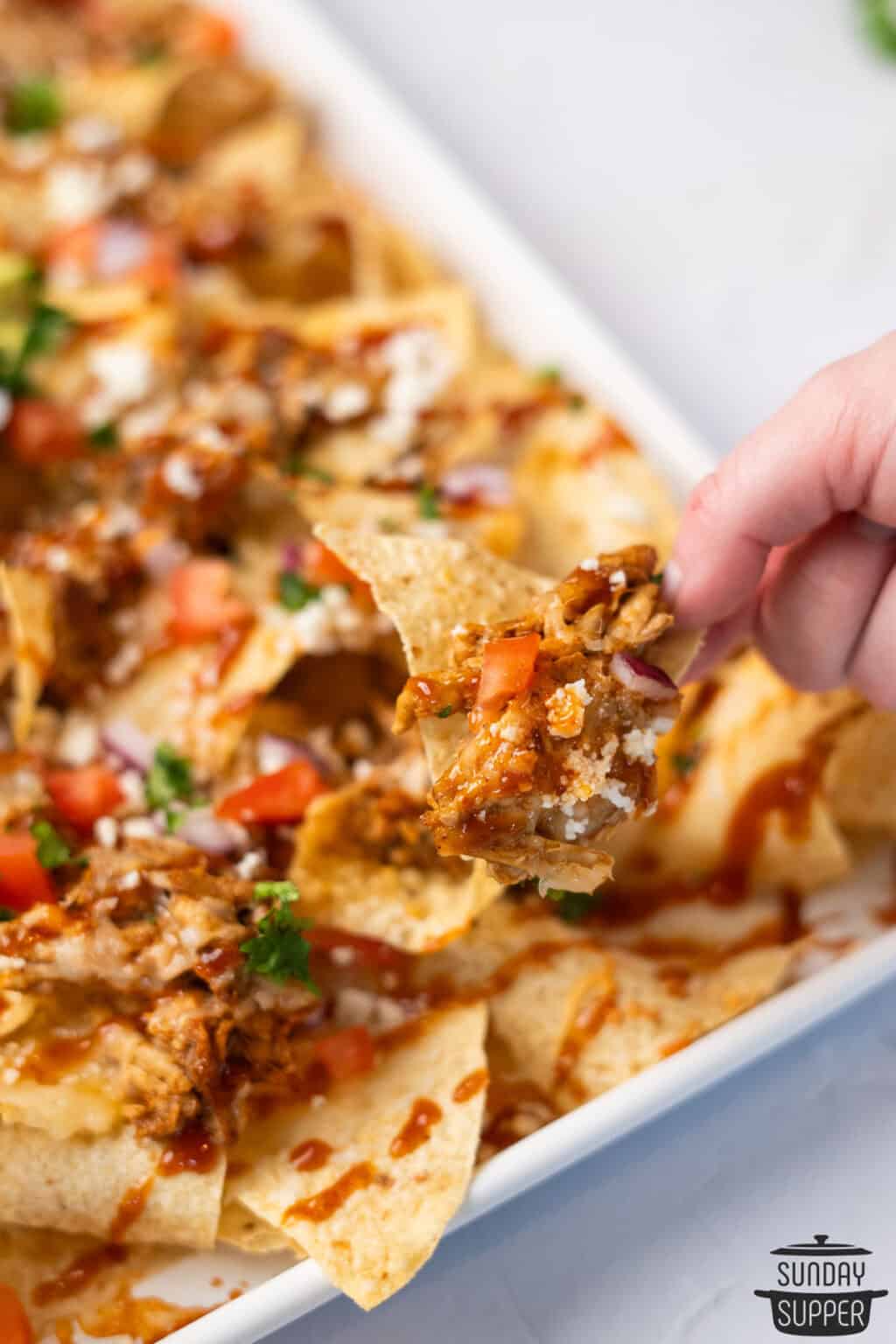 Oven-Baked Pulled Pork Nachos with Creamy Sour Cream Drizzle